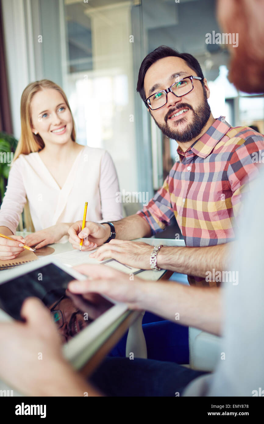 Two young managers writing down ideas of their colleague Stock Photo ...