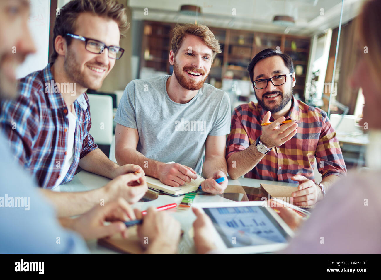 Group of male employees talking to co-worker Stock Photo - Alamy