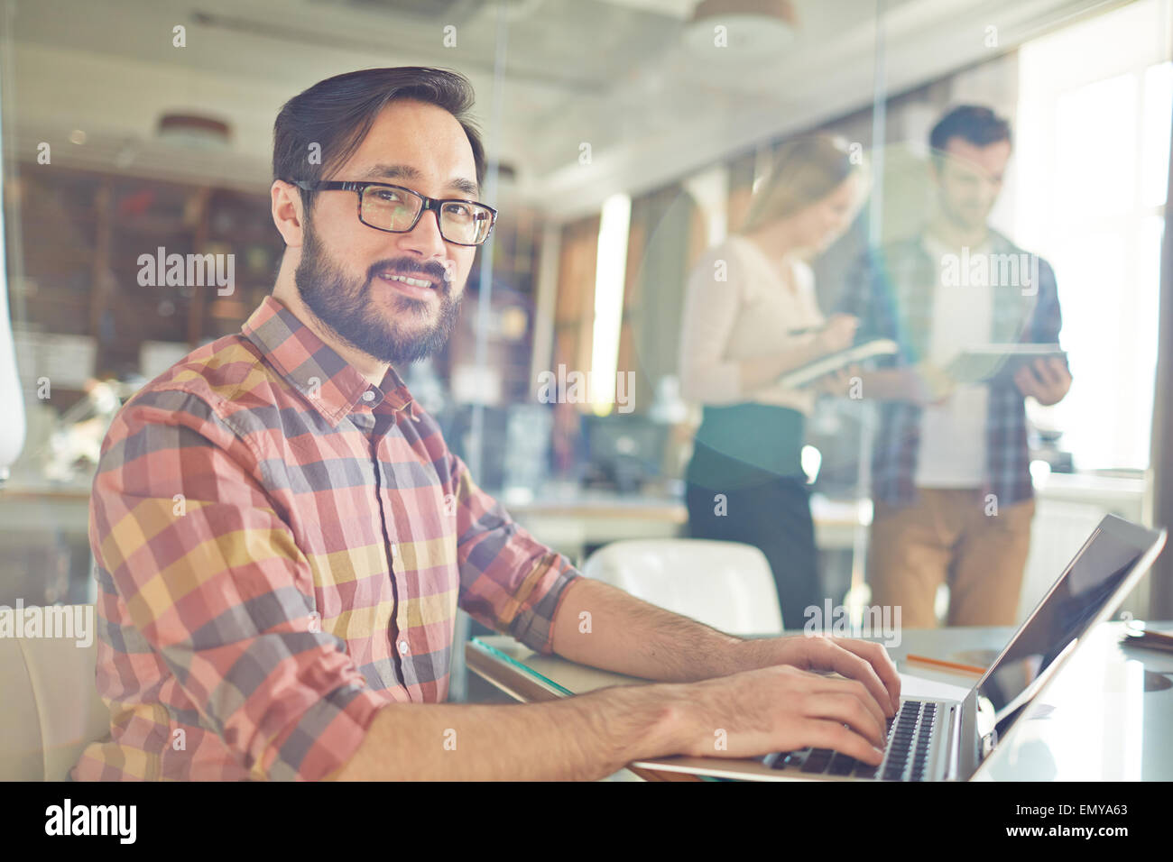 Handsome office worker typing by workplace Stock Photo - Alamy