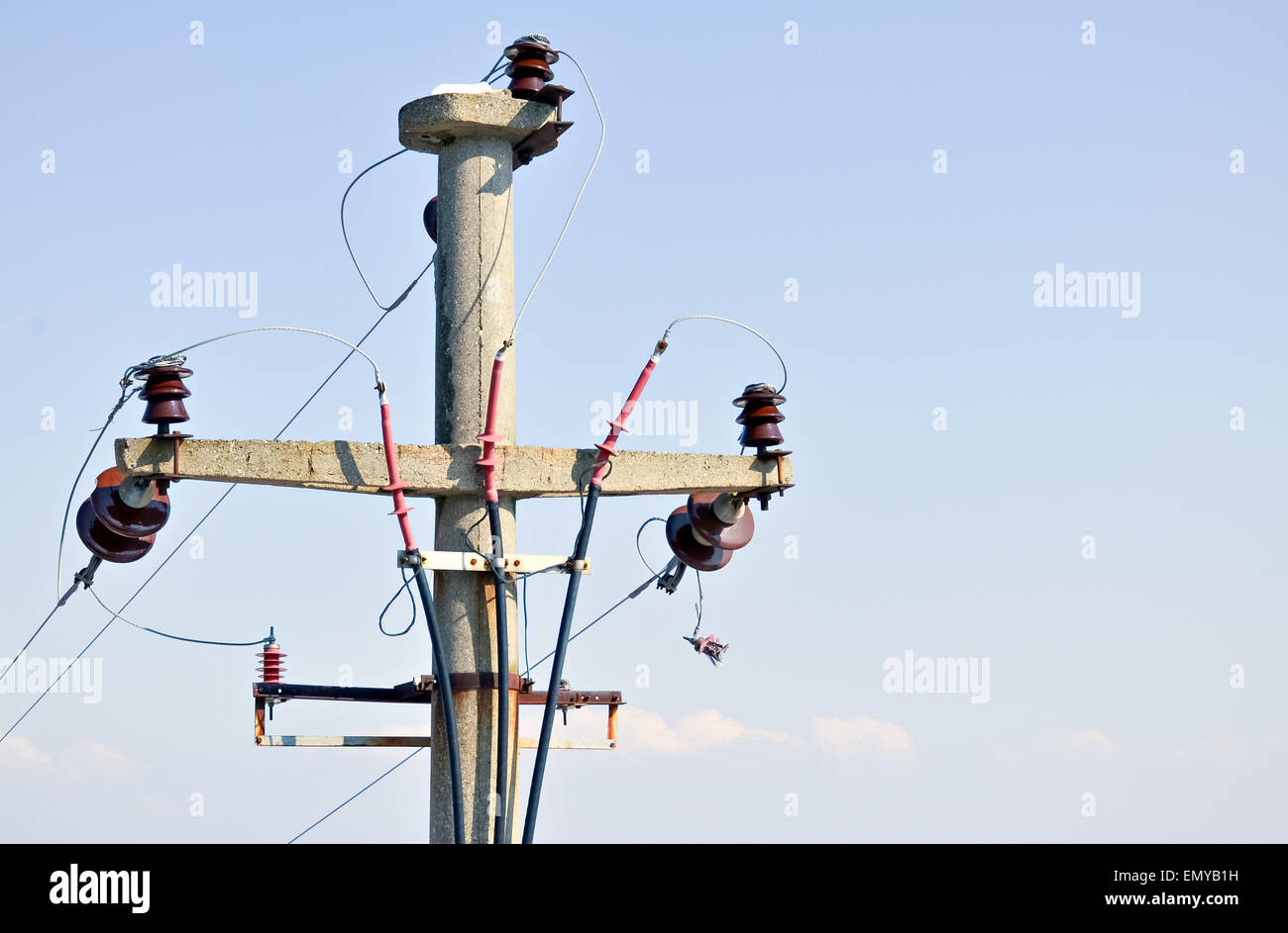 Closeup of simple three-phase electric pole with the sky in background ...