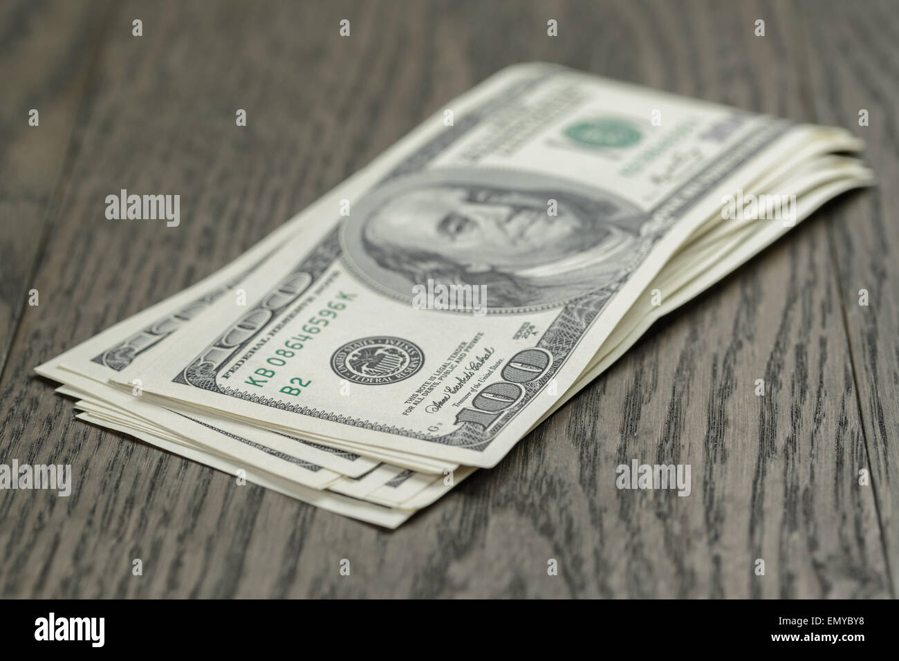 hundred dollar bills on wooden table Stock Photo - Alamy