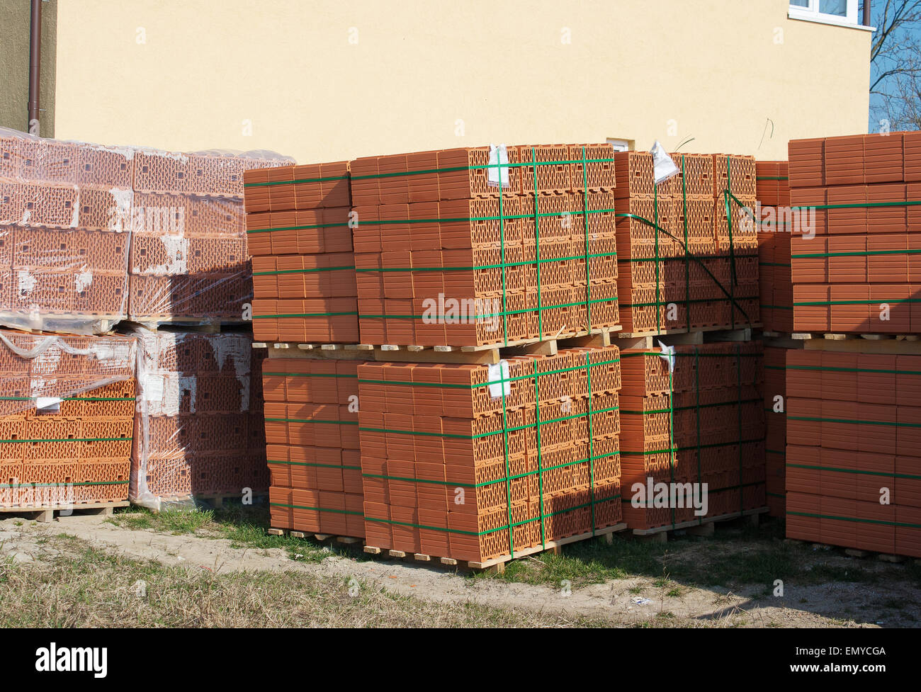 stacks of red bricks for the construction on sunny spring day outside ...