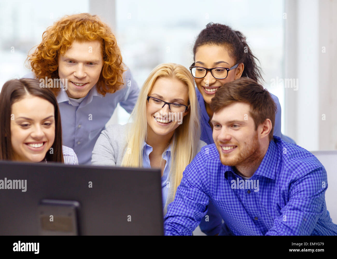 smiling business team looking at computer monitor Stock Photo - Alamy