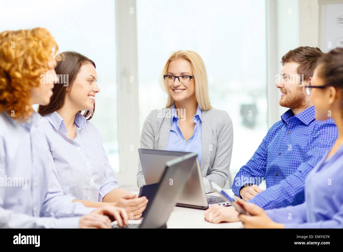 smiling team with laptop and table pc computers Stock Photo - Alamy