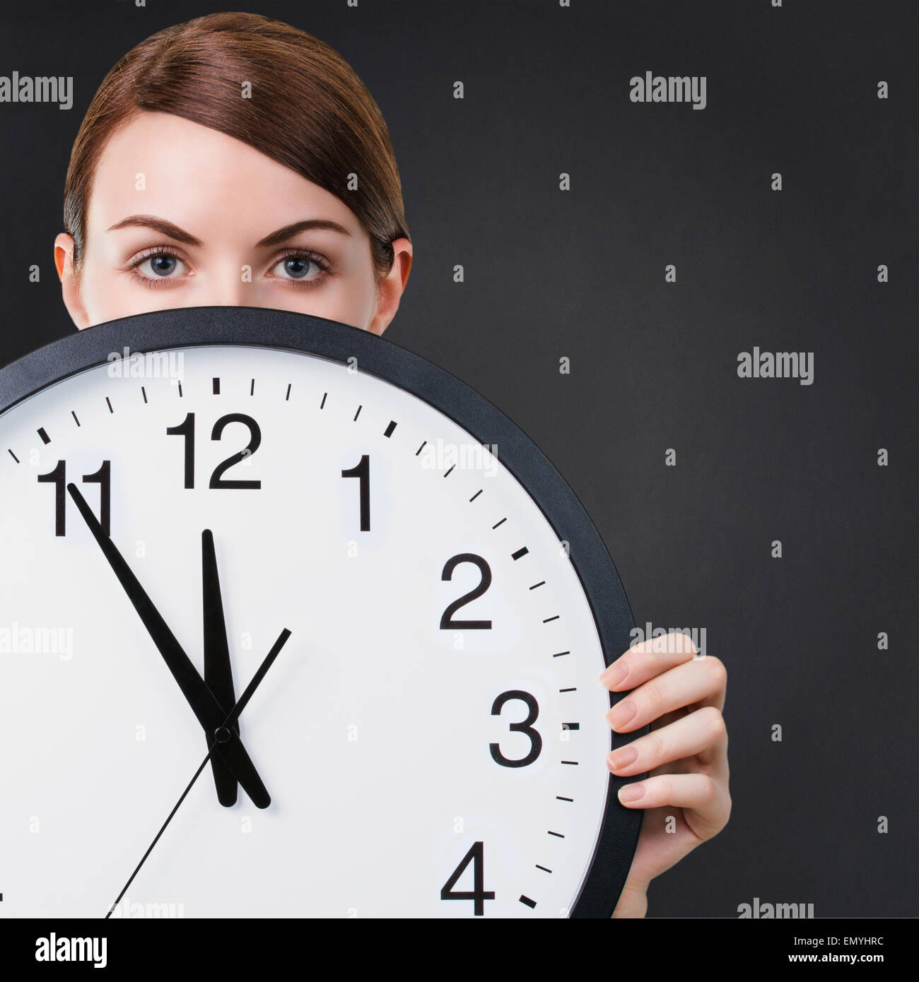 Young woman holding a clock Stock Photo - Alamy
