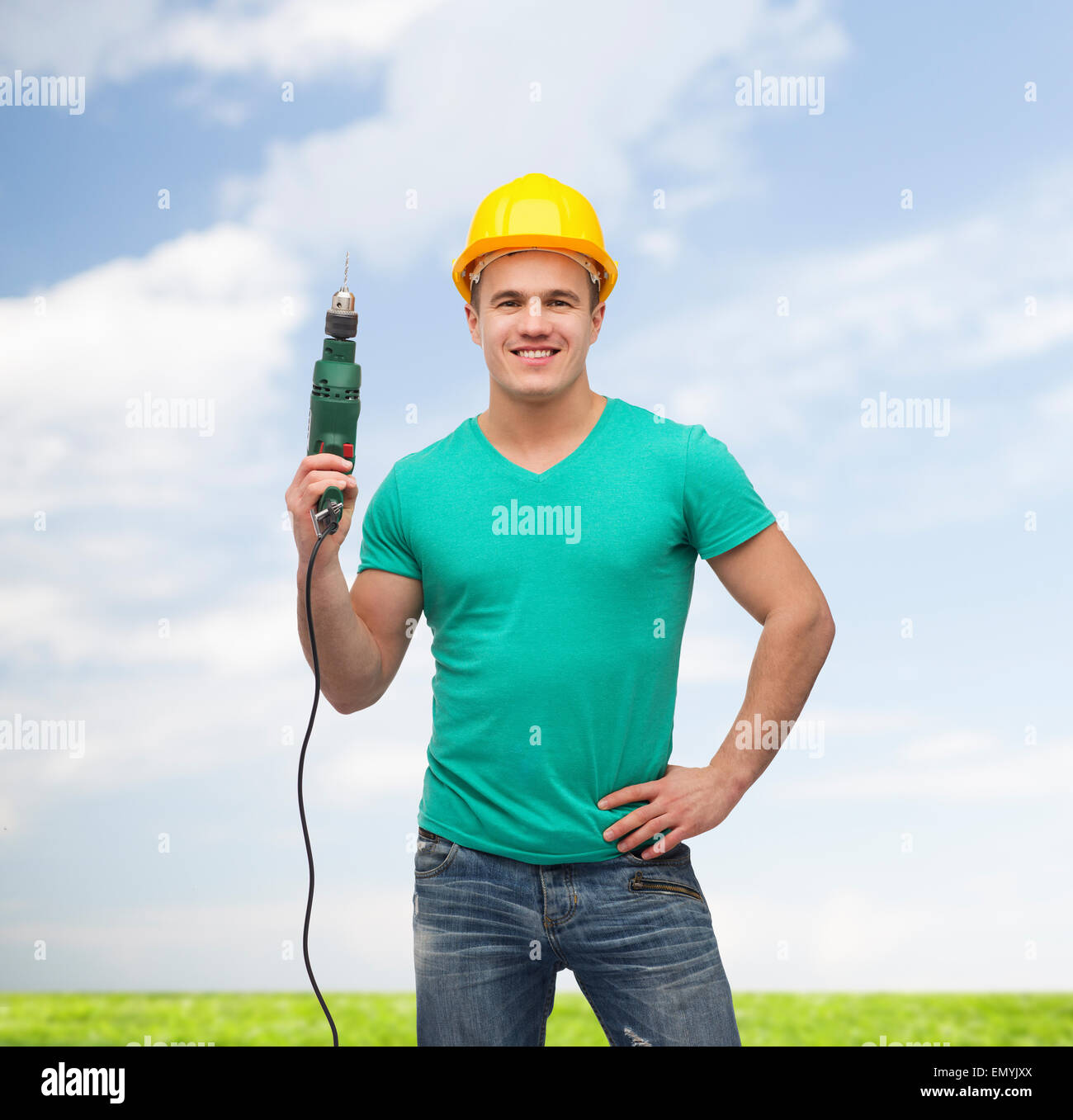 smiling manual worker in helmet with drill machine Stock Photo - Alamy