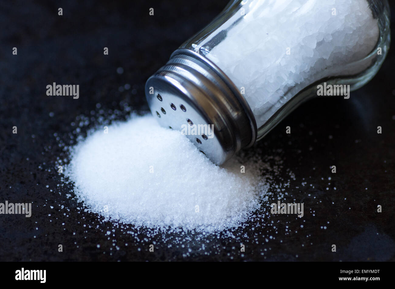 Salt shaker with large and small salt on a black background Stock Photo ...