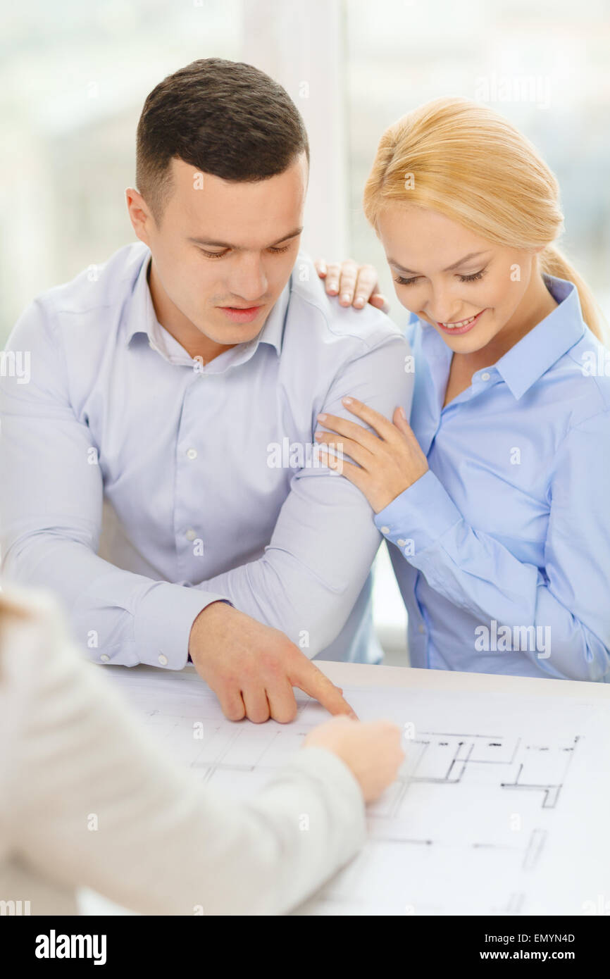 smiling couple looking at blueprint Stock Photo - Alamy