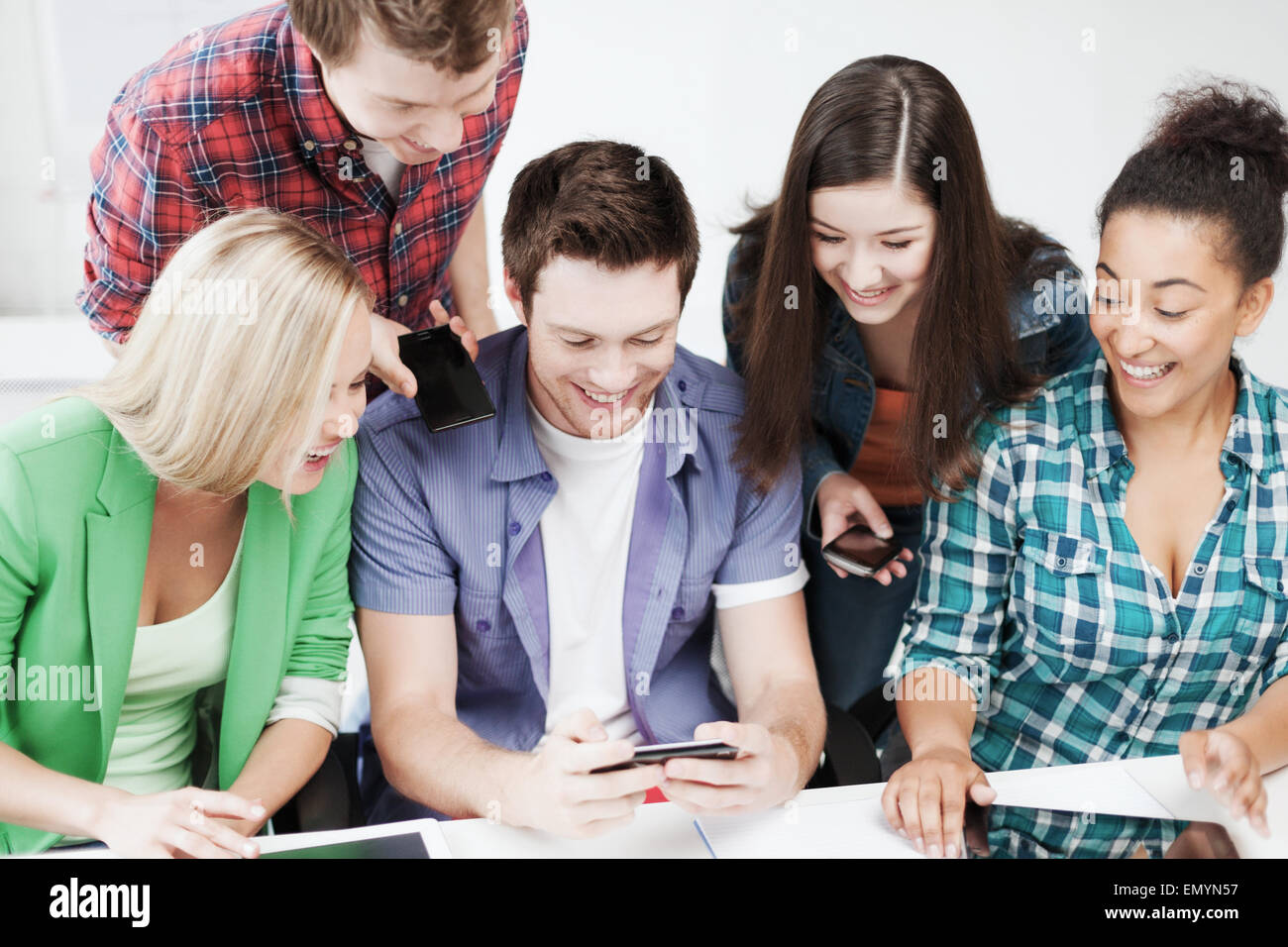 students looking into smartphone at school Stock Photo - Alamy