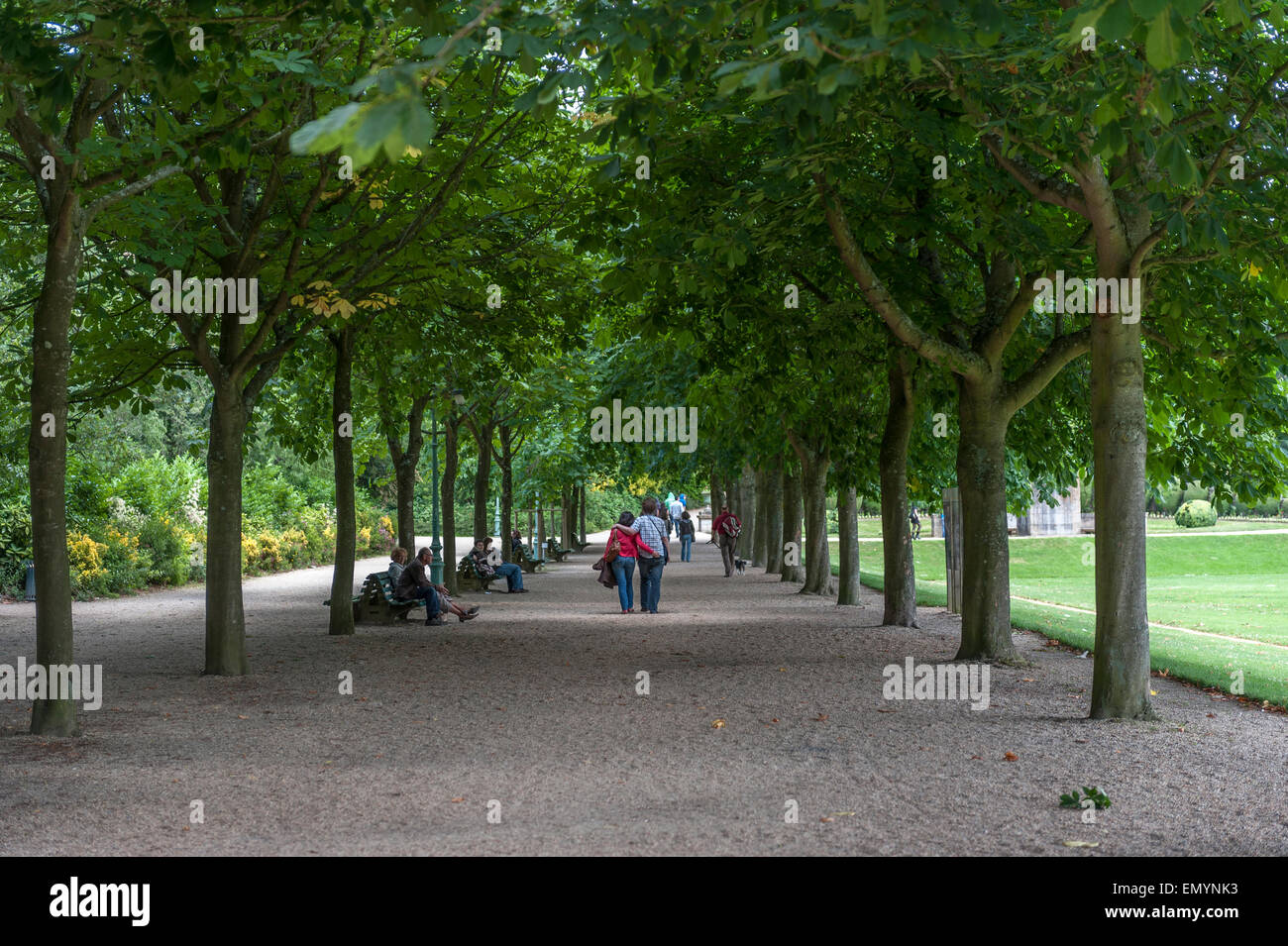 Couple walking arm in arm in a tree lined park. Parc du Thabor. Thabor ...