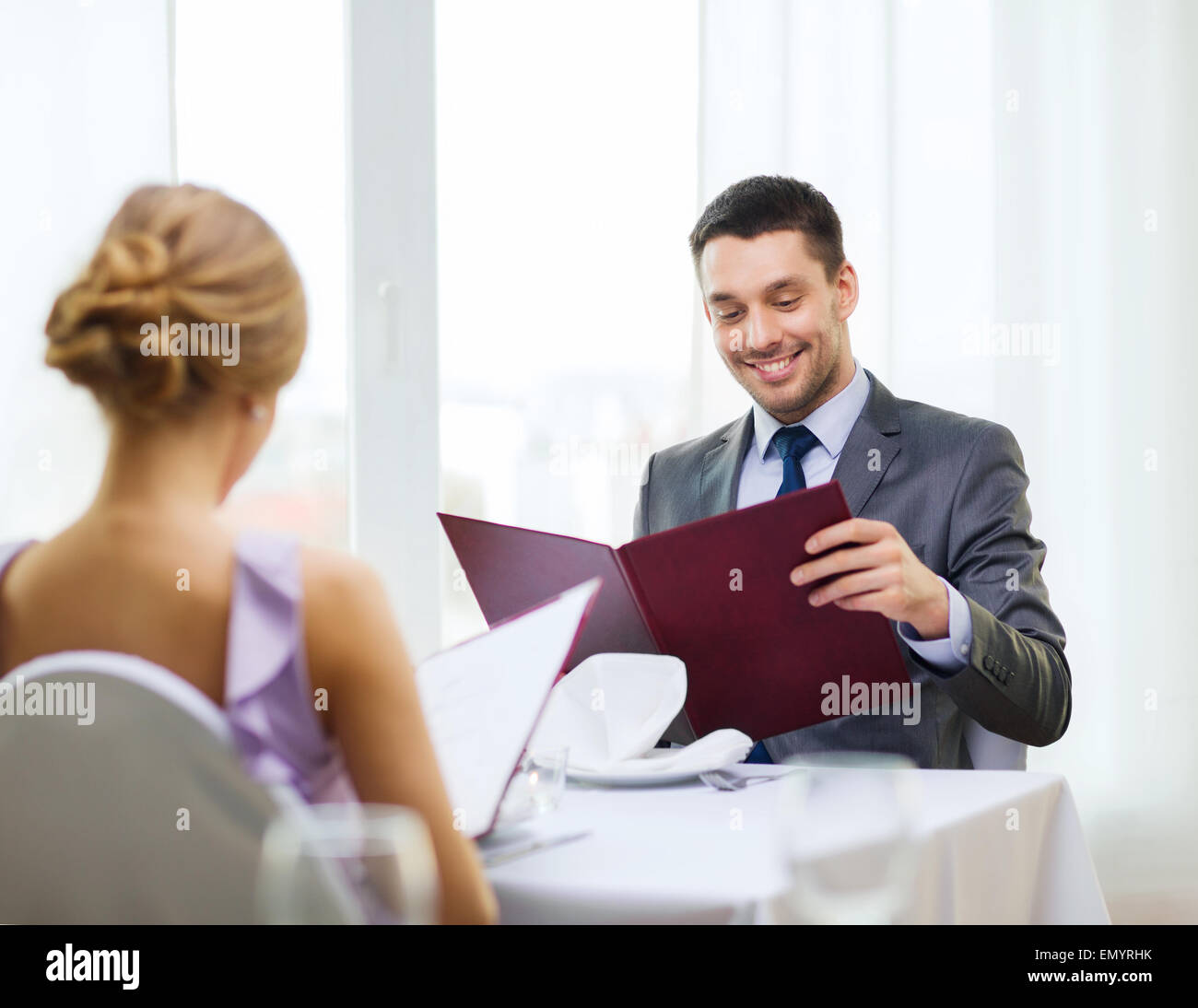 smiling young man looking at menu at restaurant Stock Photo - Alamy