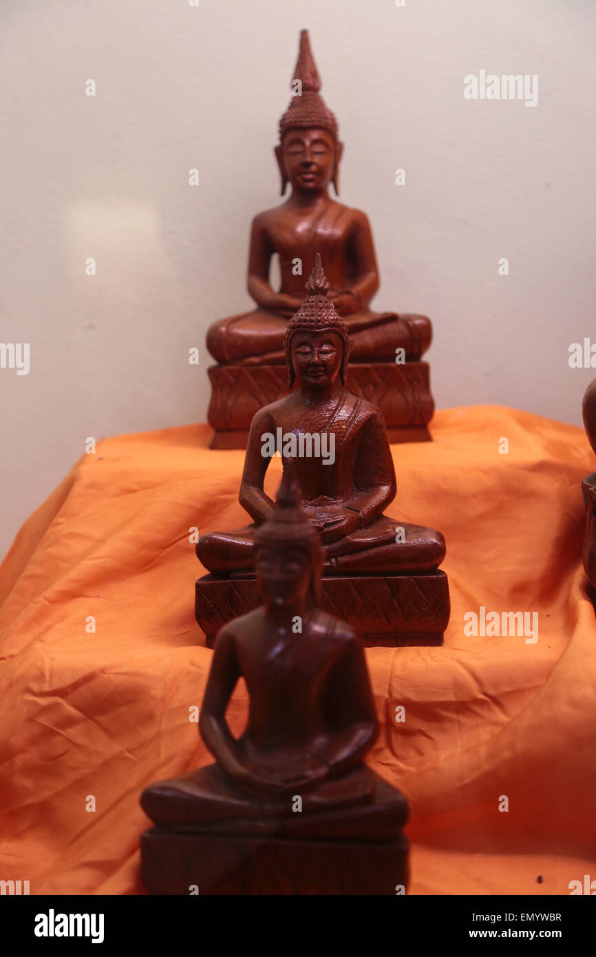 Various buddha statues made of hard wood inside a display cabinet at ...