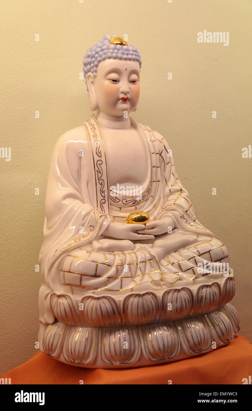 Sitting buddha statues made of porcelain inside a display cabinet at ...