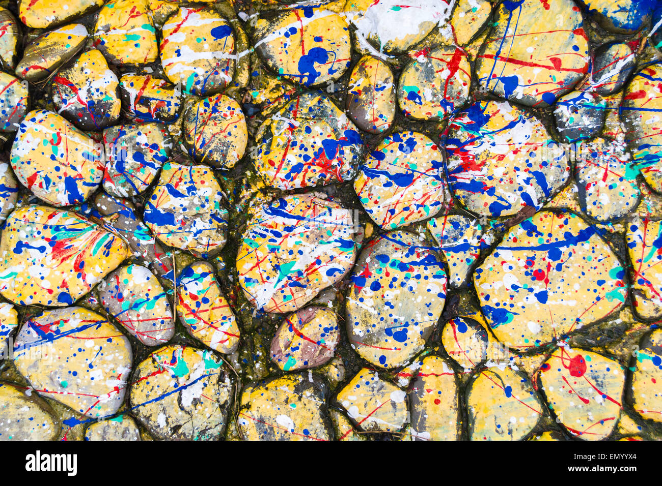 Stones covered in paint drops and drips creating a distinctive splatter ...