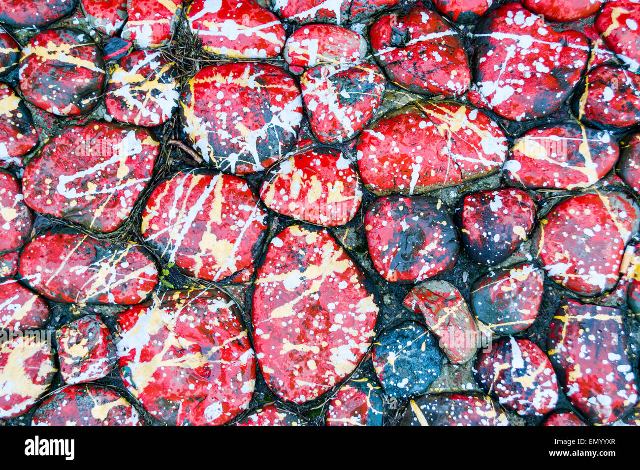 Stones covered in paint drops and drips creating a distinctive splatter ...