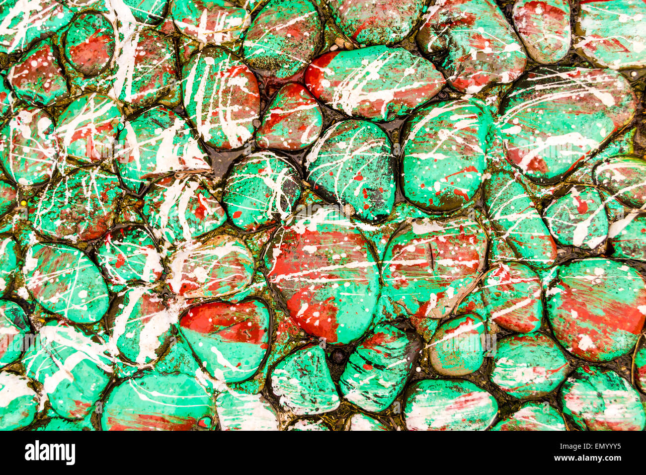 Stones covered in paint drops and drips creating a distinctive splatter ...