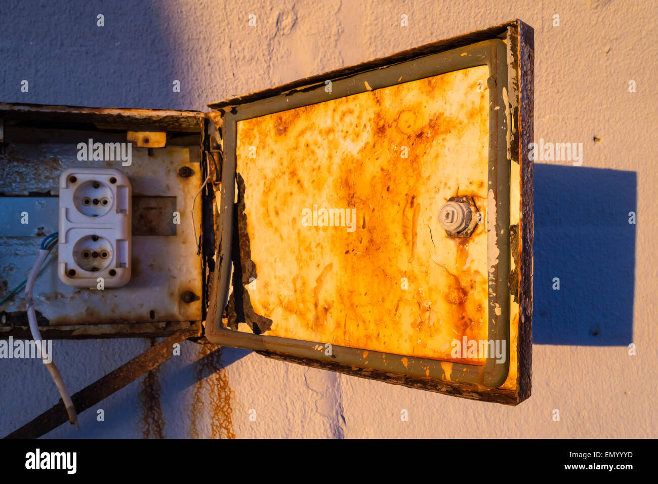 Rusty and unused electrical box with plugs and cut cables in sunlight ...