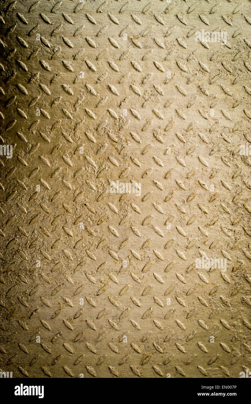 A walkway path of gold painted metal with flaking and deterioration ...