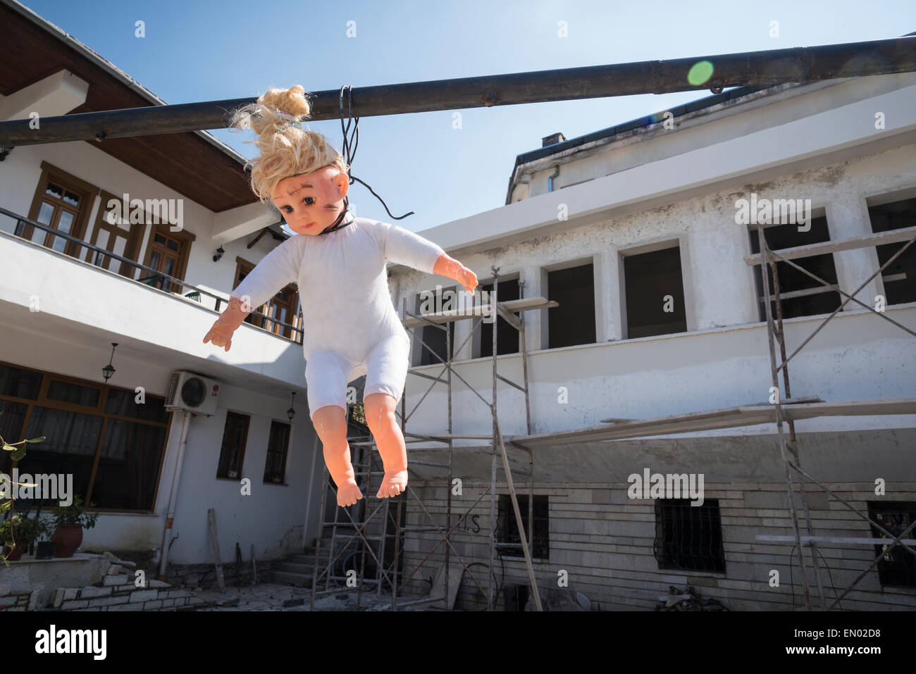 A dordolec, in this case, a childs doll hung outside a new building to ...