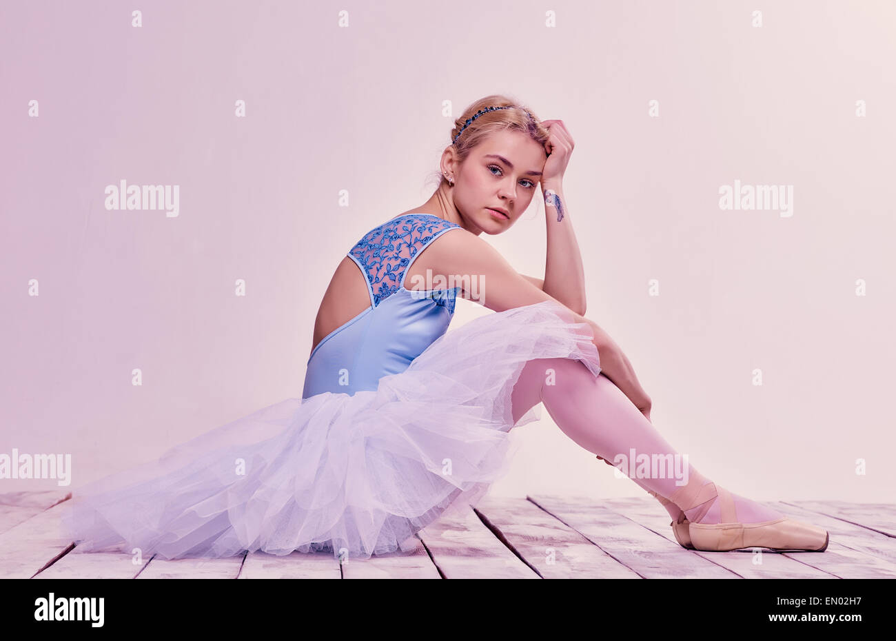 Tired ballet dancer sitting on the wooden floor Stock Photo - Alamy