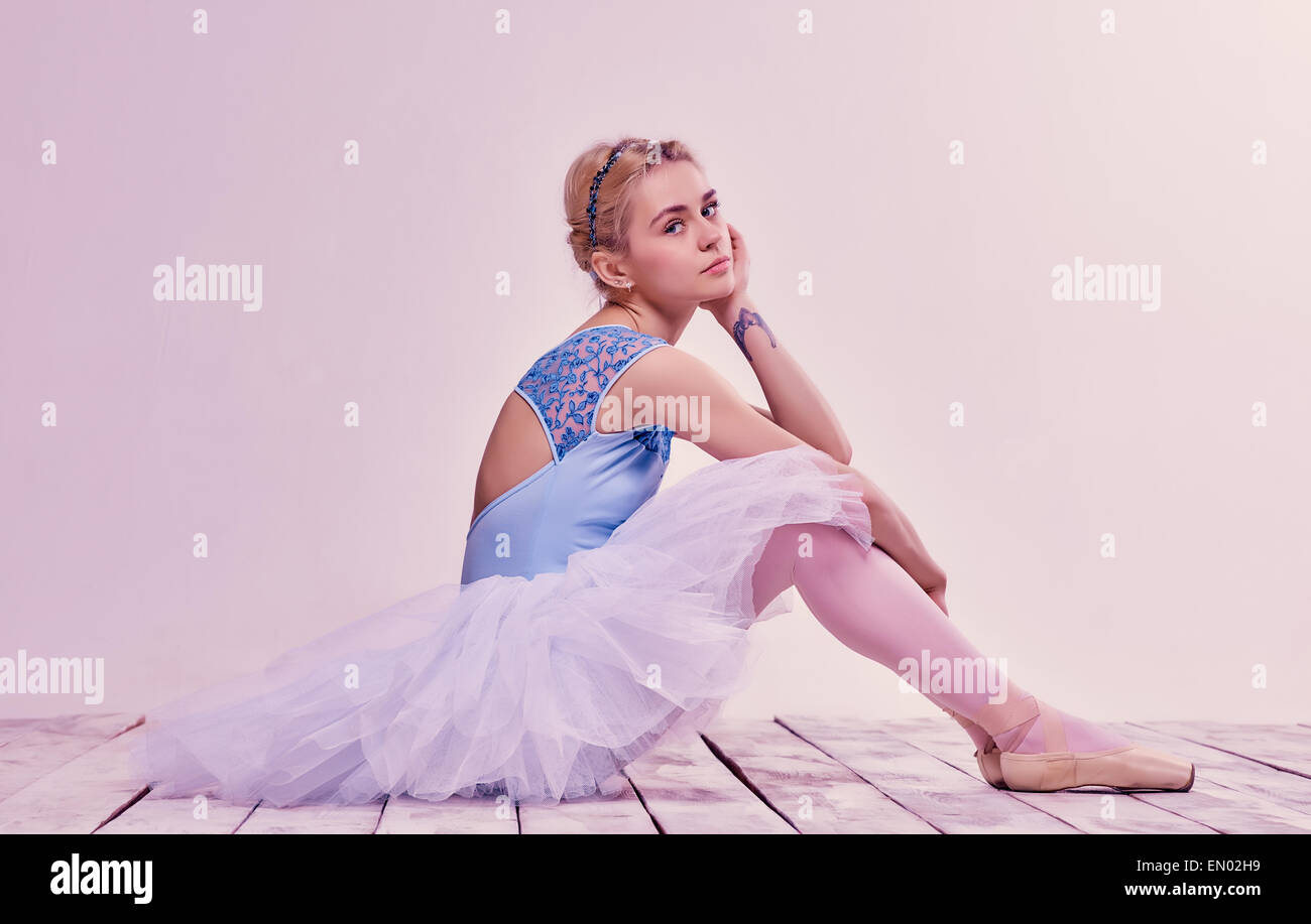 Tired ballet dancer sitting on the wooden floor Stock Photo - Alamy