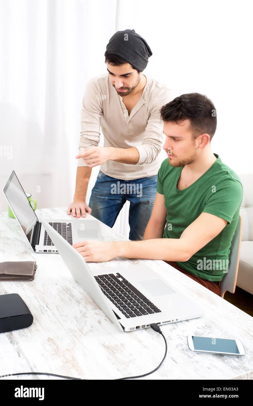 Two workmates teaming up and working together Stock Photo - Alamy
