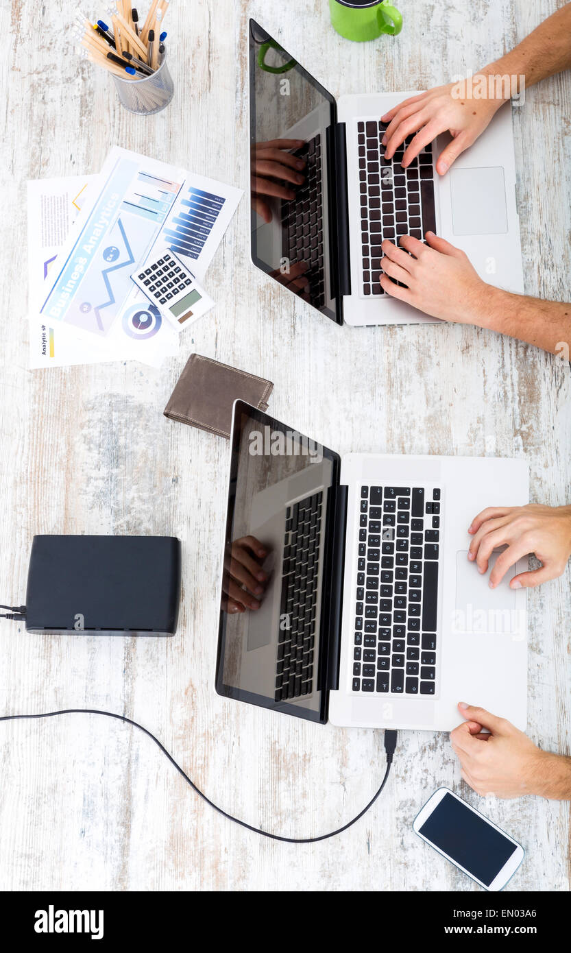 Two workmates teaming up and working together Stock Photo - Alamy