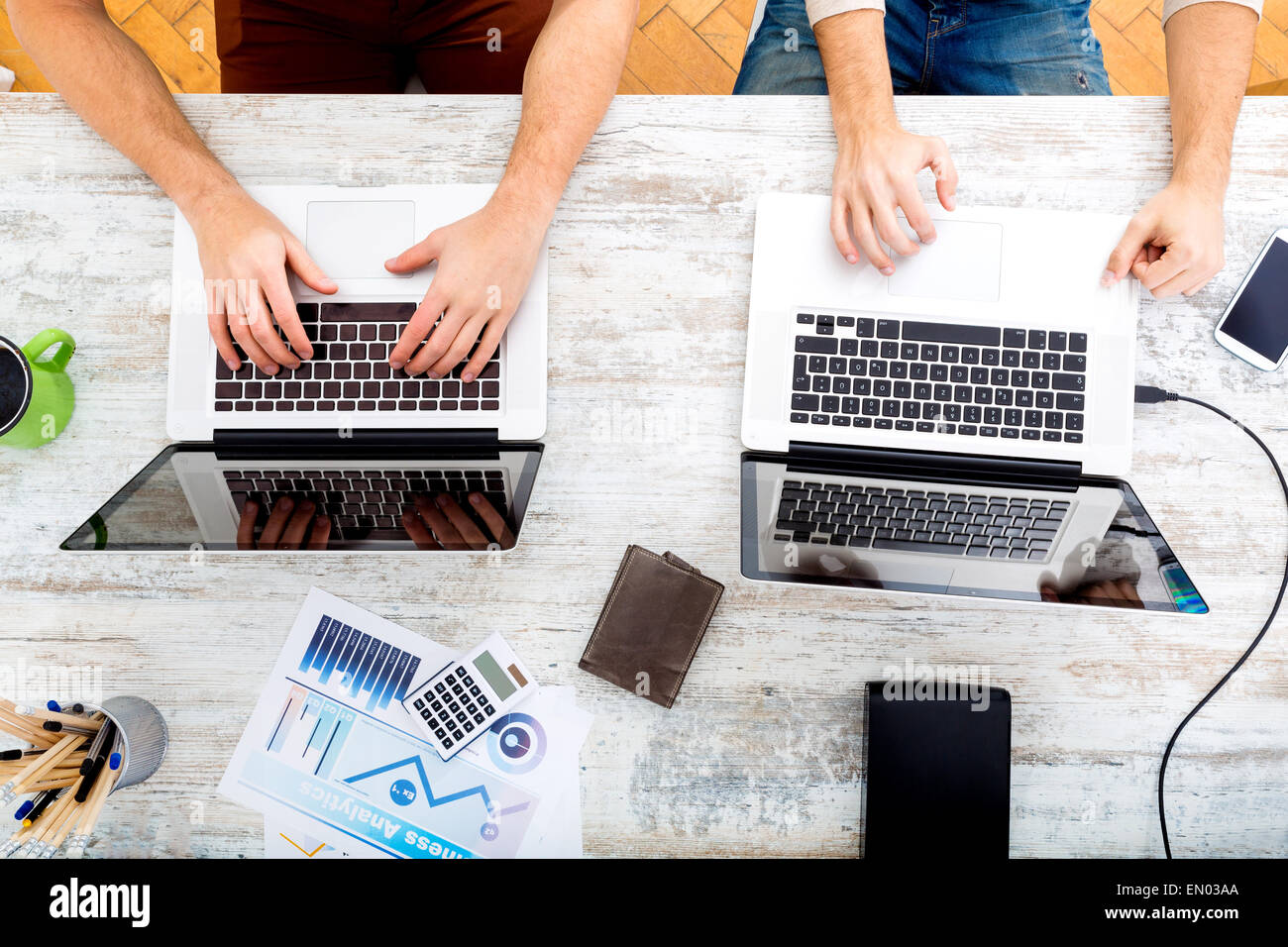 Two workmates teaming up and working together Stock Photo - Alamy