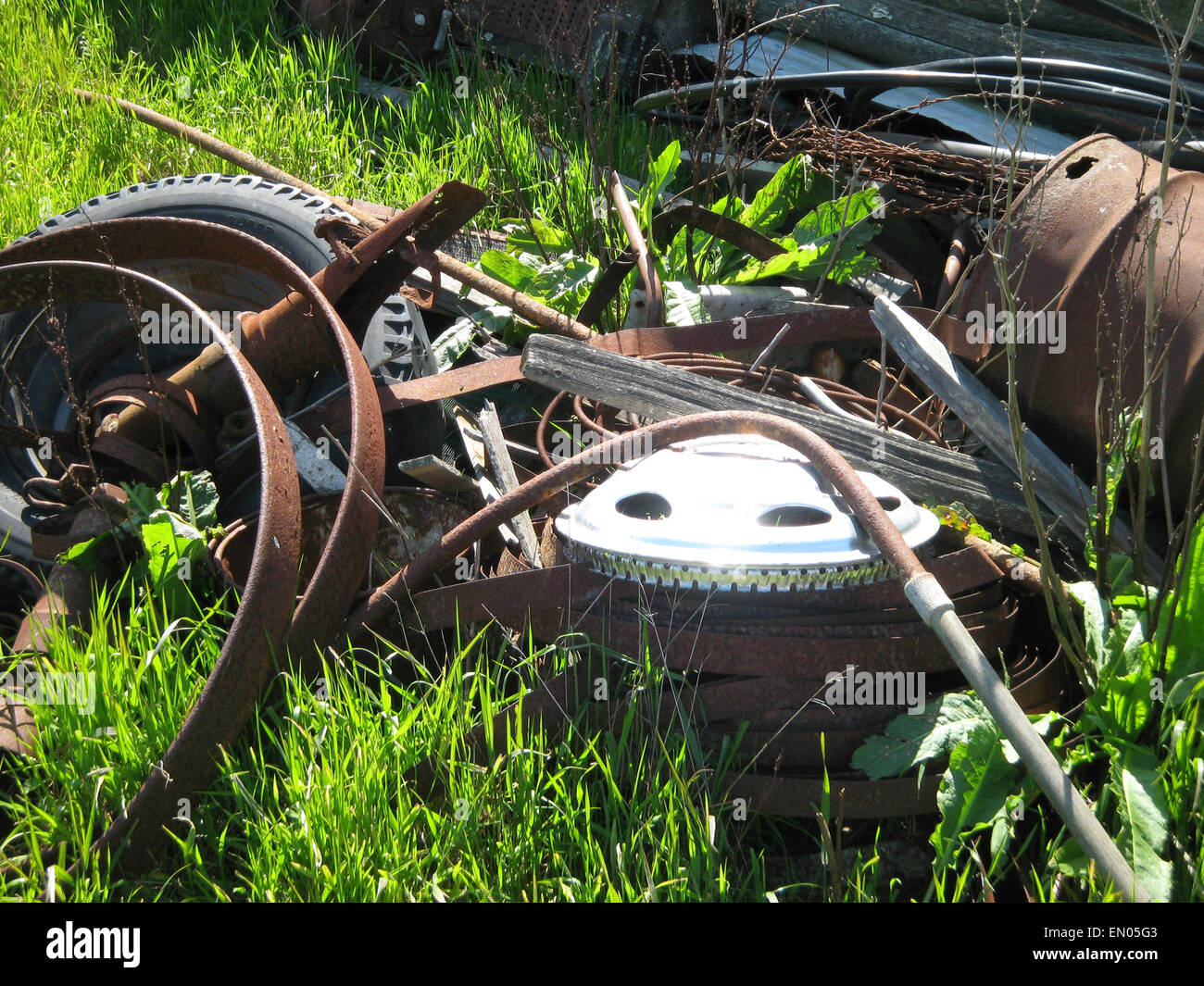 Rusted old farm equipment left in the grass at an old farmhouse in ...
