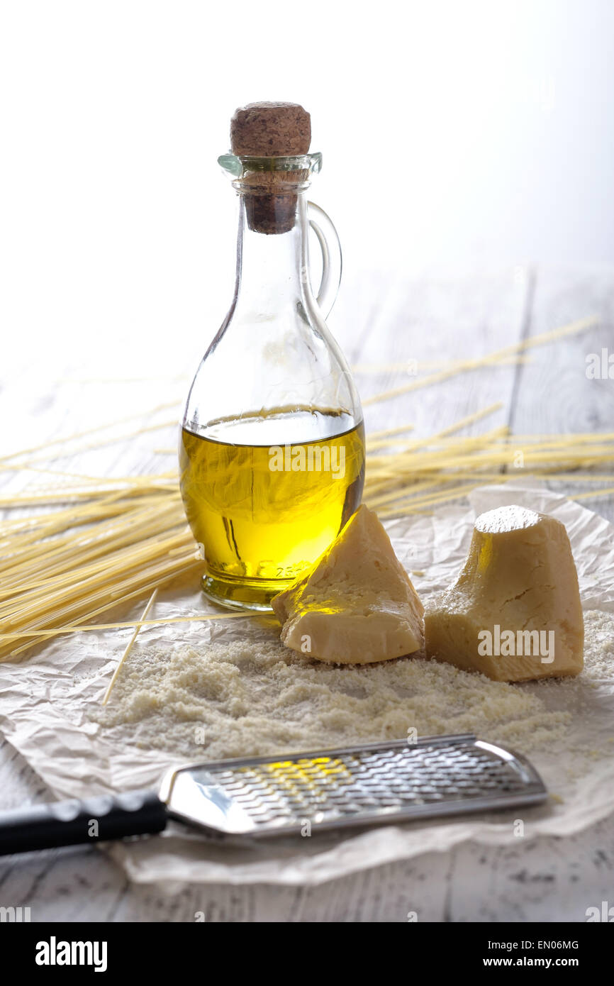Grated parmesan cheese, bottle of olive oil and metal grater on wooden ...