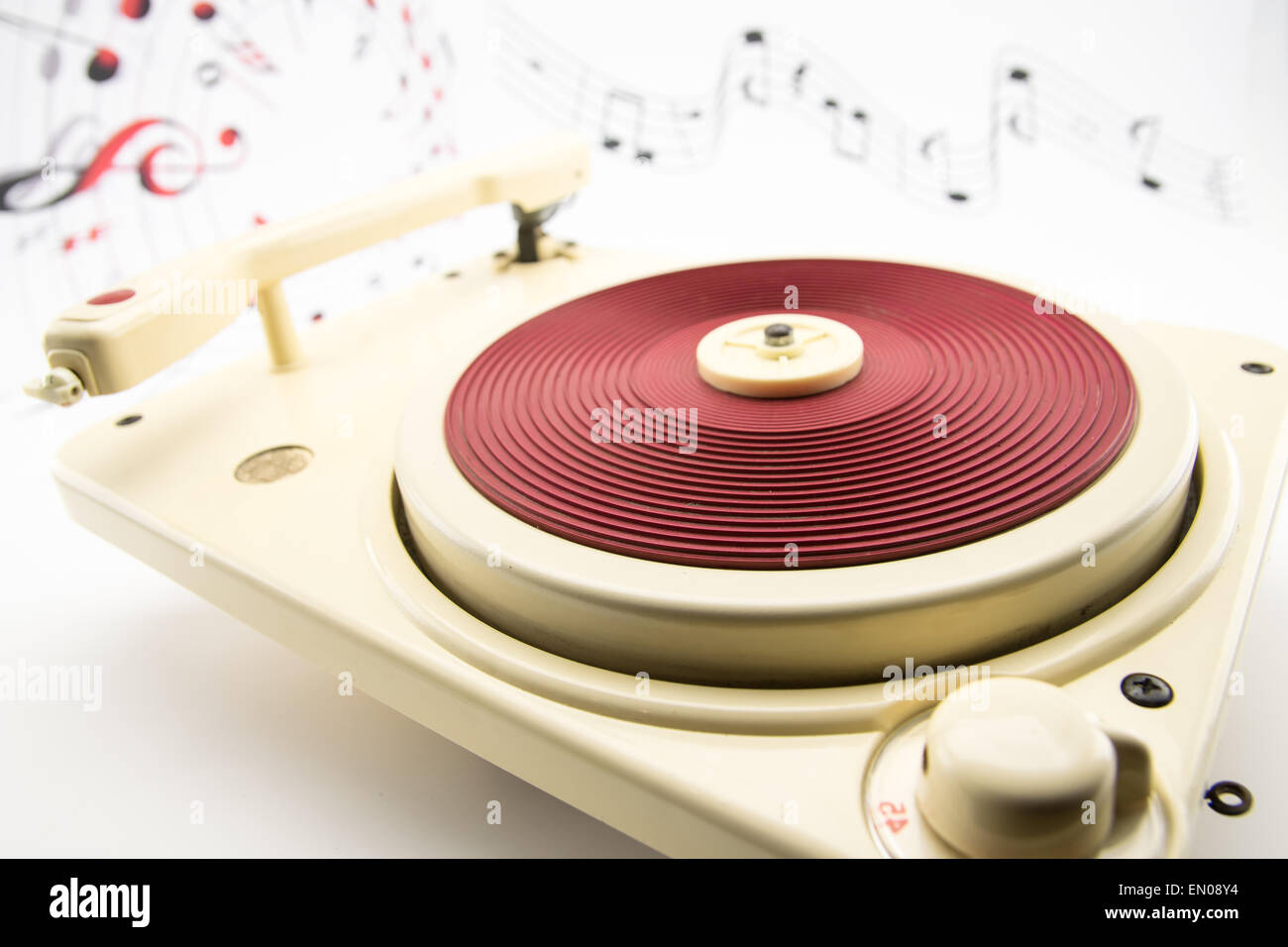 composition with vintage red record player and musical notes on ...