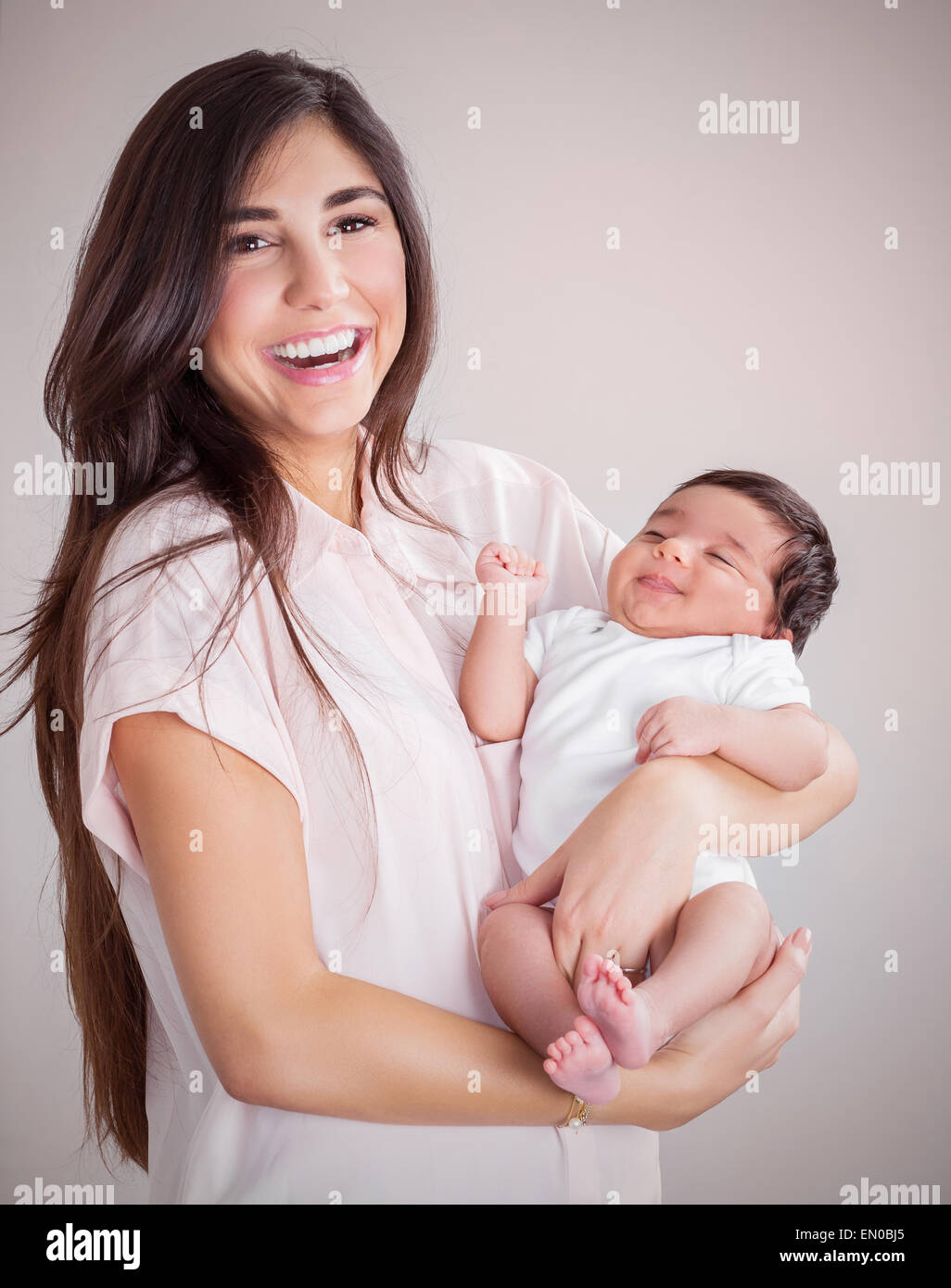 Beautiful mother with little baby portrait isolated on gray background ...