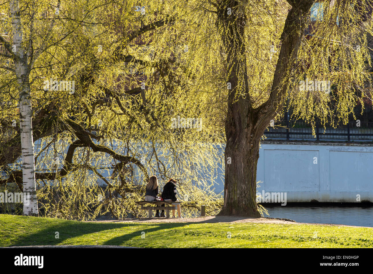 Two young women enjoy a sunny day during early spring in Norrkoping ...