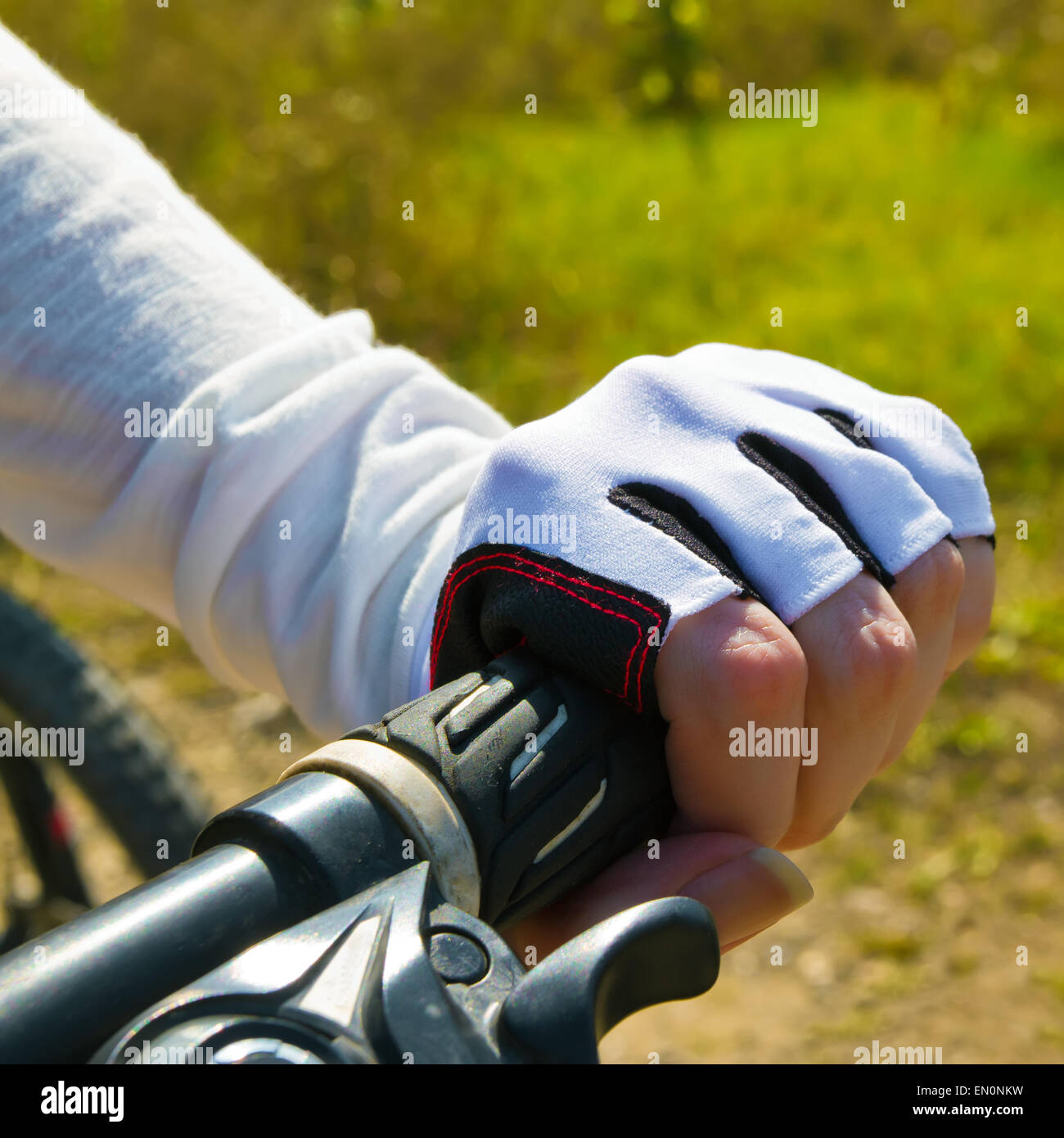 Hand holding a handle bar. Woman riding a bicycle in a park Stock Photo ...