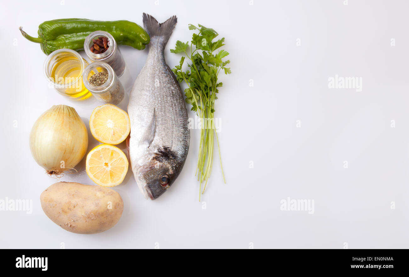 Raw sea bream fish with some ingredients. Isolated over white ...
