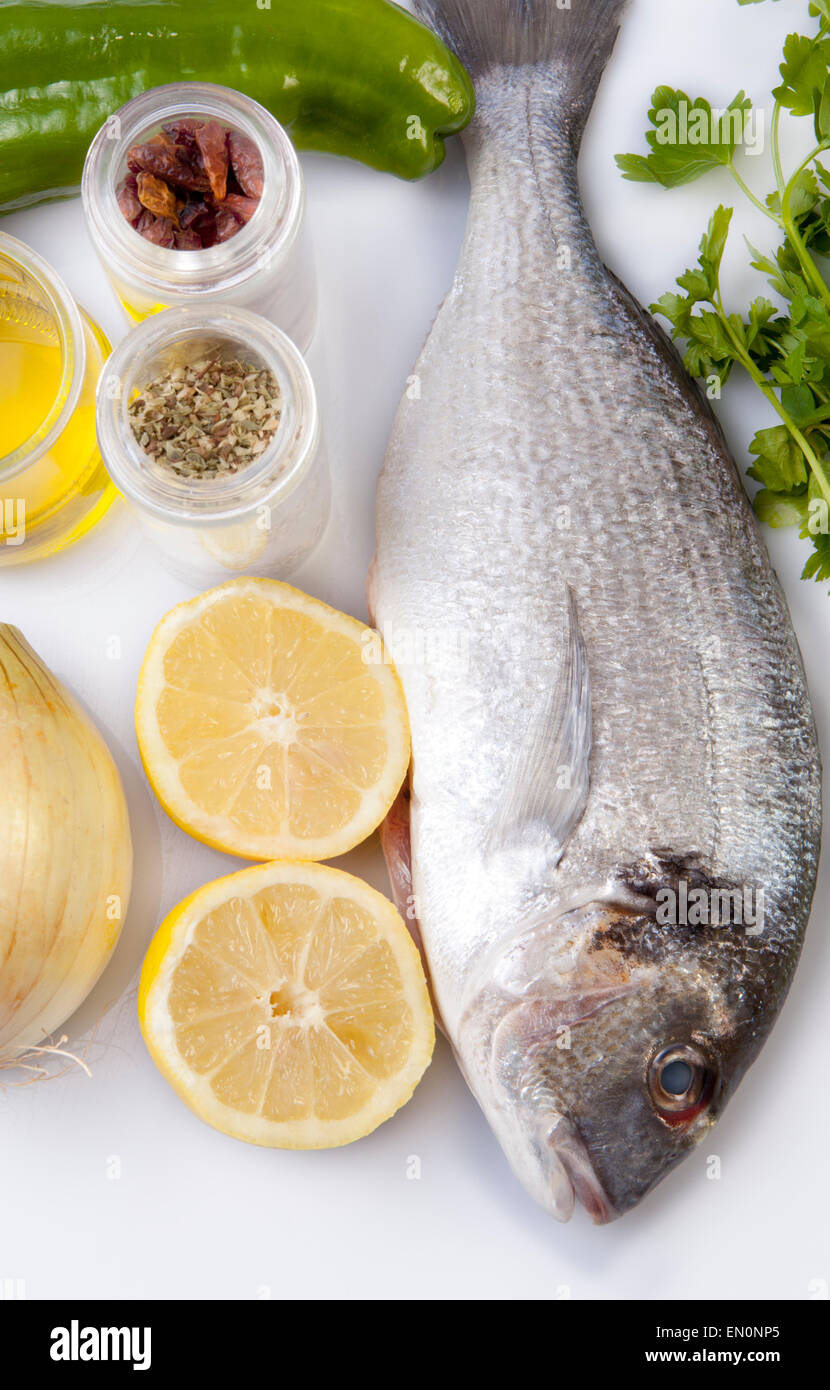 Raw sea bream fish with some ingredients. Isolated over white ...