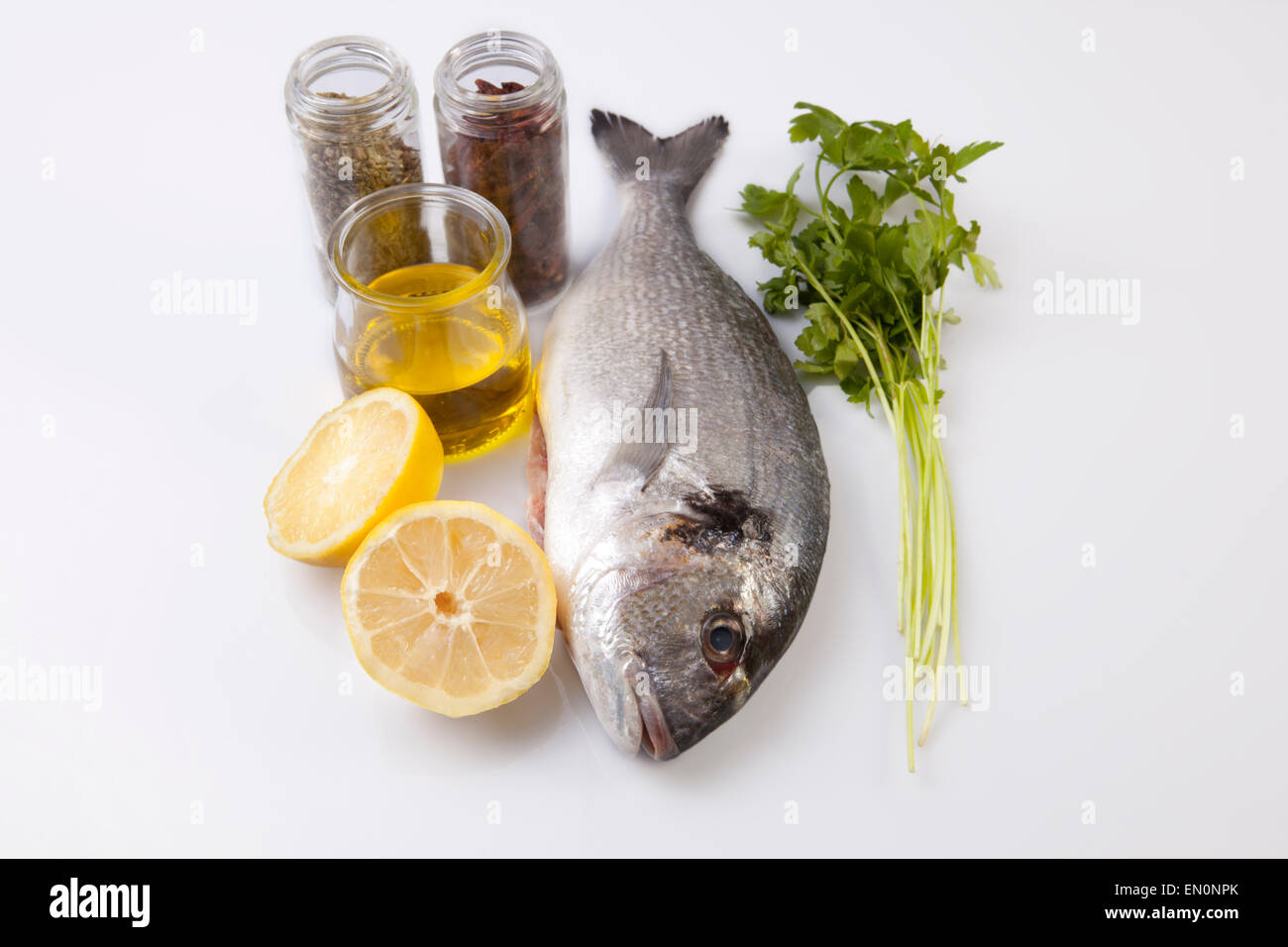 Raw sea bream fish with some ingredients. Isolated over white ...