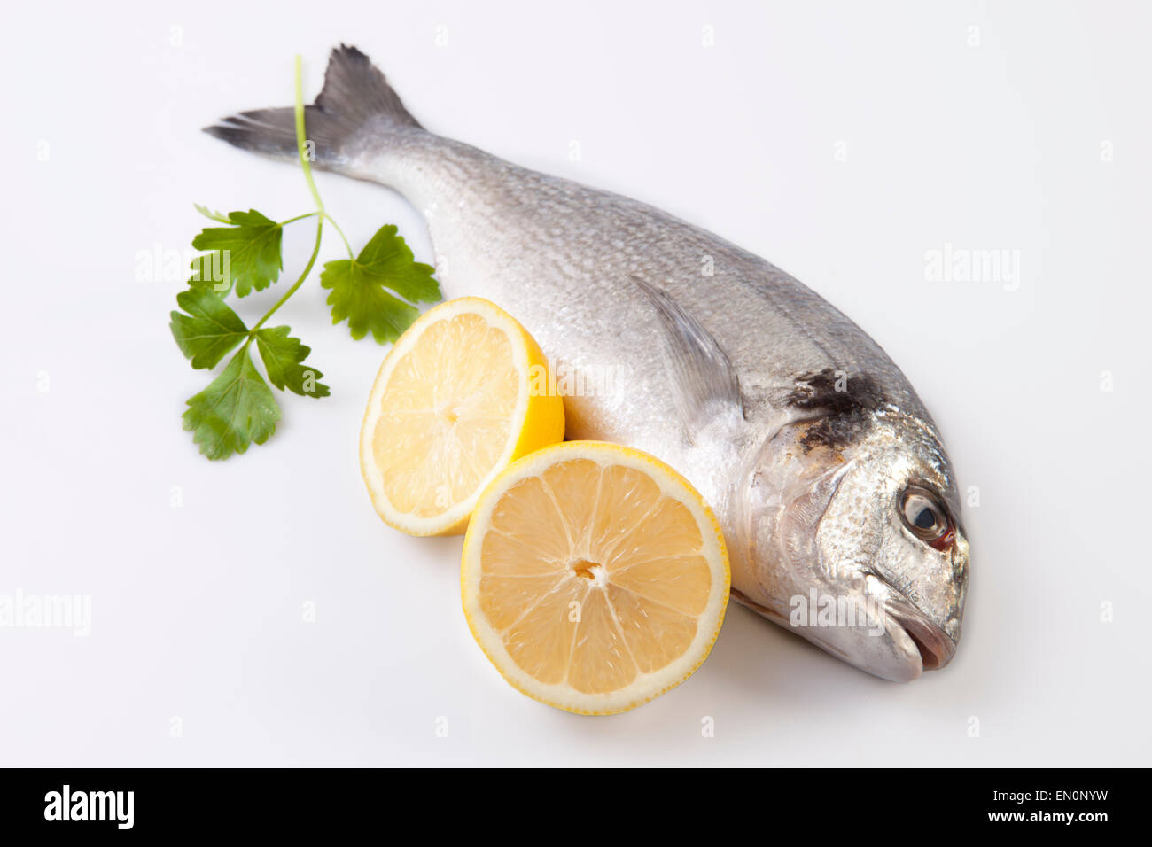 Raw sea bream fish with some ingredients. Isolated over white ...