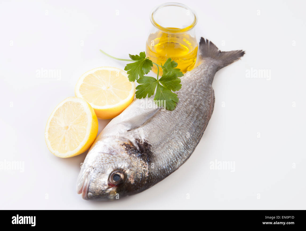 Raw sea bream fish with some ingredients. Isolated over white ...