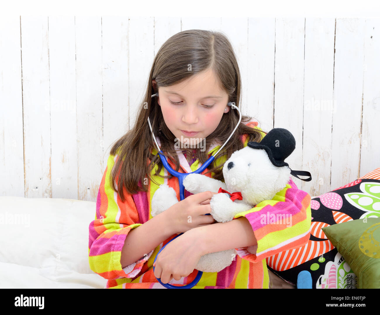 a sick little girl playing with her teddy in her bed Stock Photo - Alamy