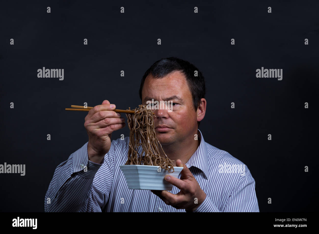 Guy experiencing how difficult it can be to eat with chopsticks Stock ...