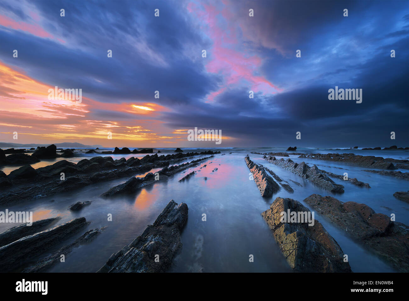 rocks in Barrika beach with a dramatic sky Stock Photo - Alamy