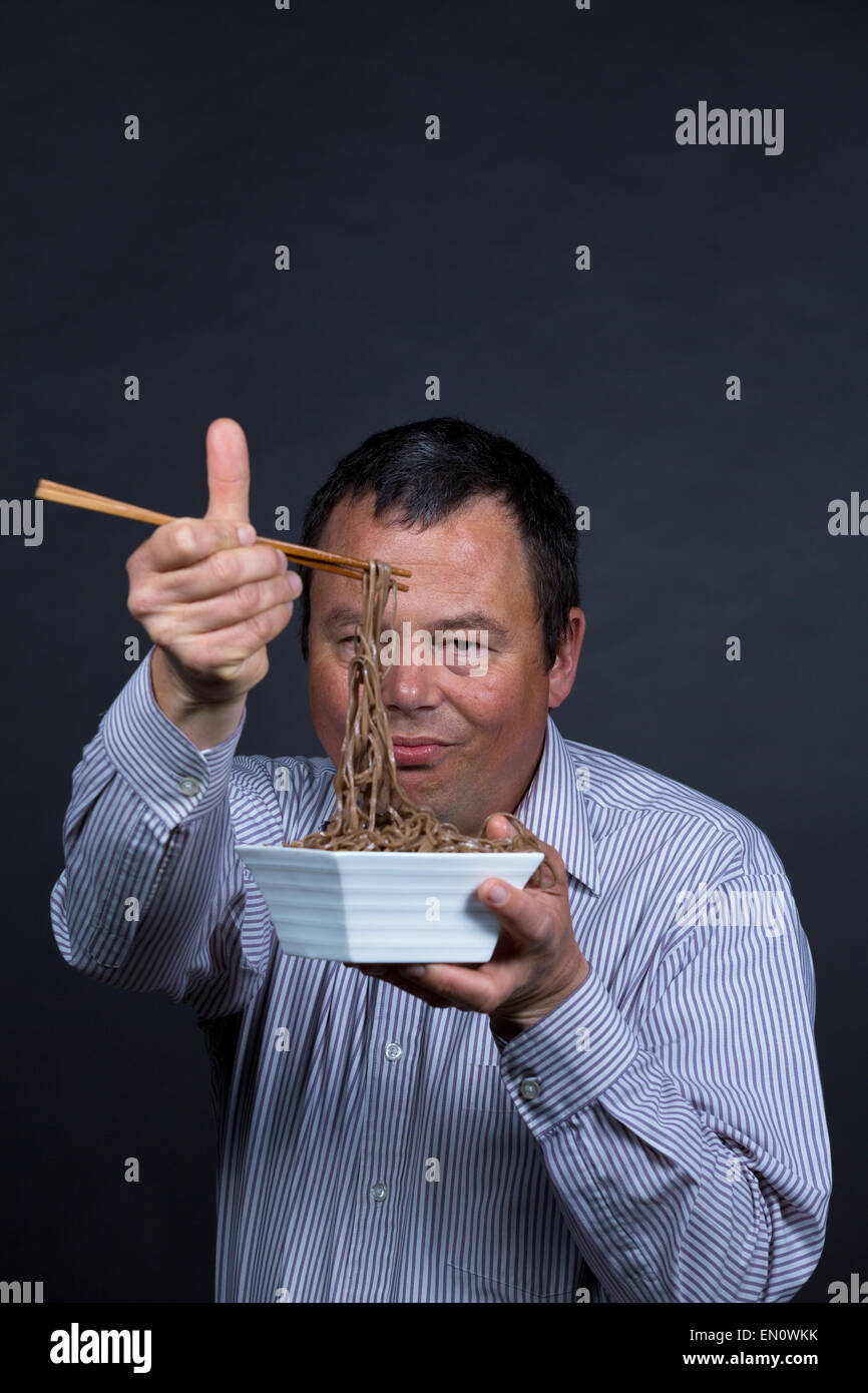 Guy getting pretty fed up with his attempts on eating with chopsticks ...