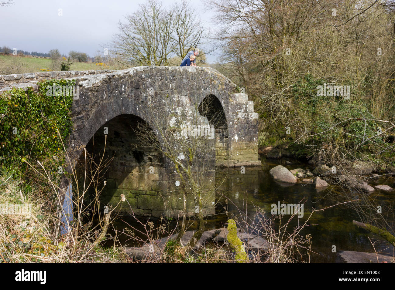 River Dart at Hexworthy Bridge, Dartmoor. People looking into water ...