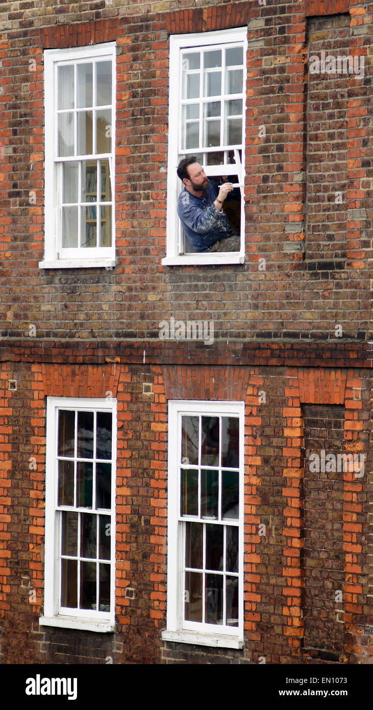 Man painting his window frame Stock Photo - Alamy
