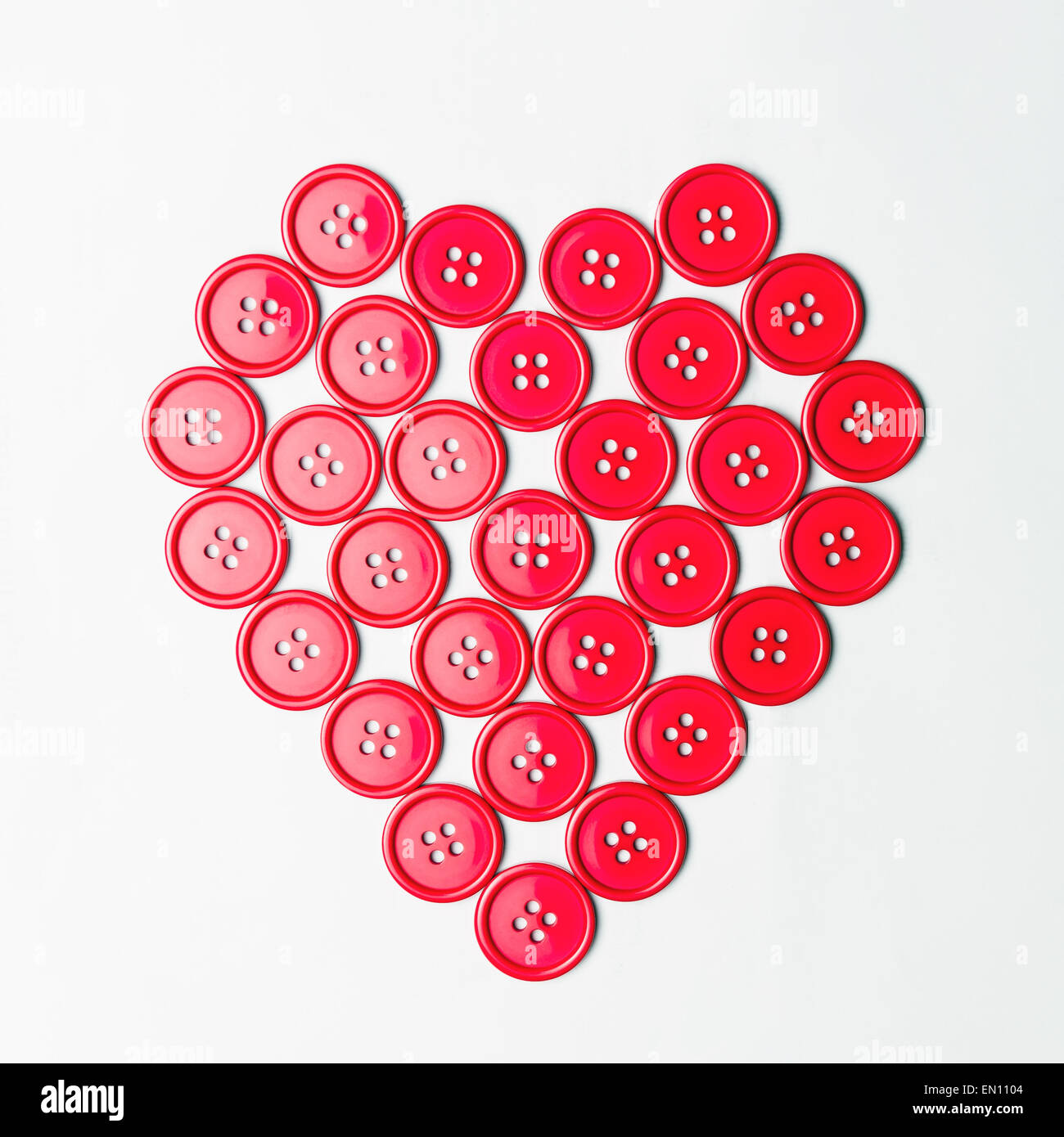 Red sewing buttons arranged in a heart shape over white backgrou Stock ...