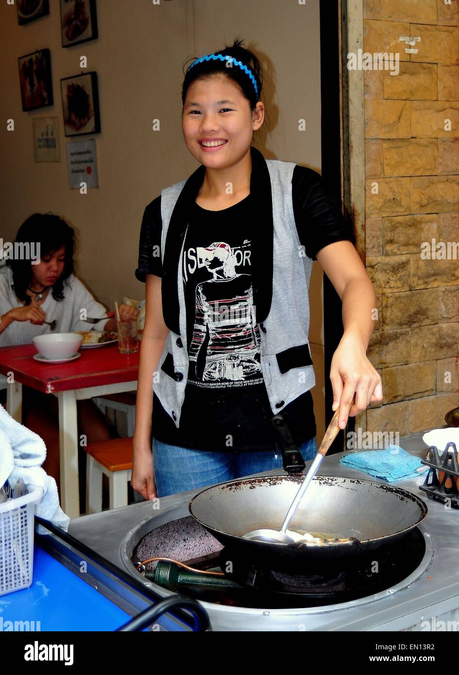 Bangkok, Thailand : Smiling Thai woman cooking at a wok in her ...