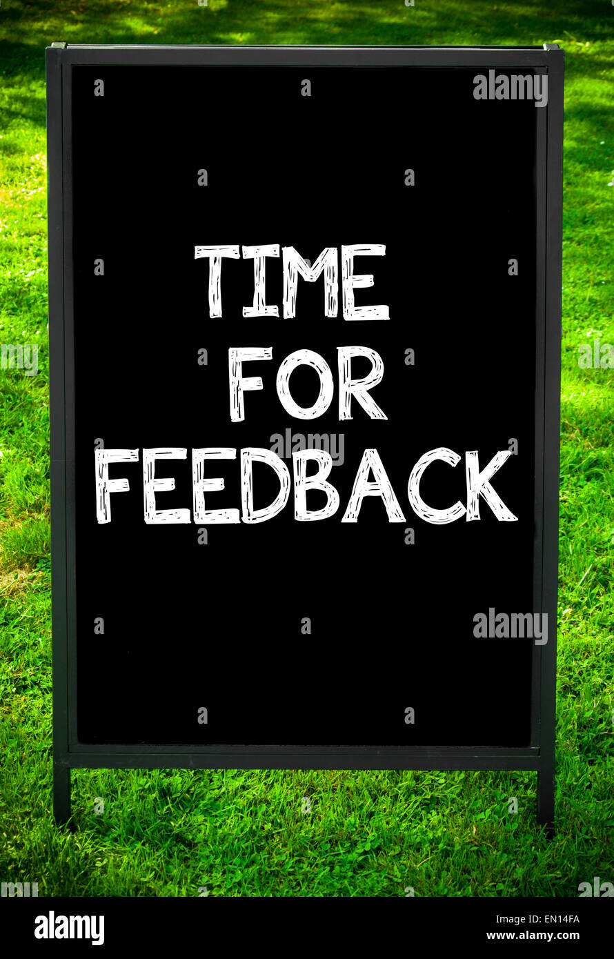 TIME FOR FEEDBACK message on sidewalk blackboard sign against green ...