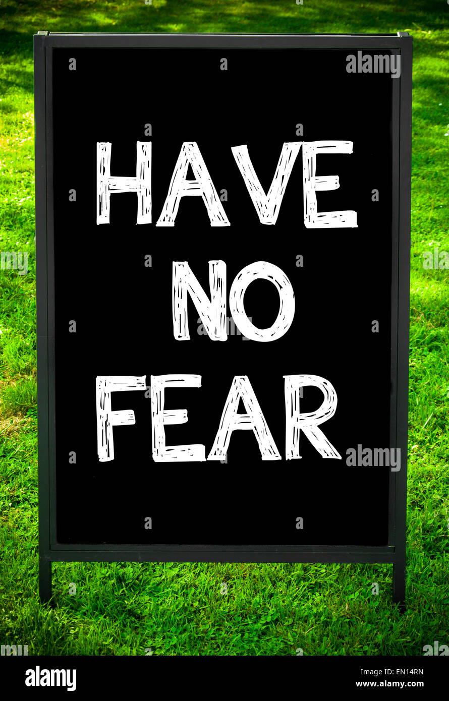 HAVE NO FEAR message on sidewalk blackboard sign against green grass ...