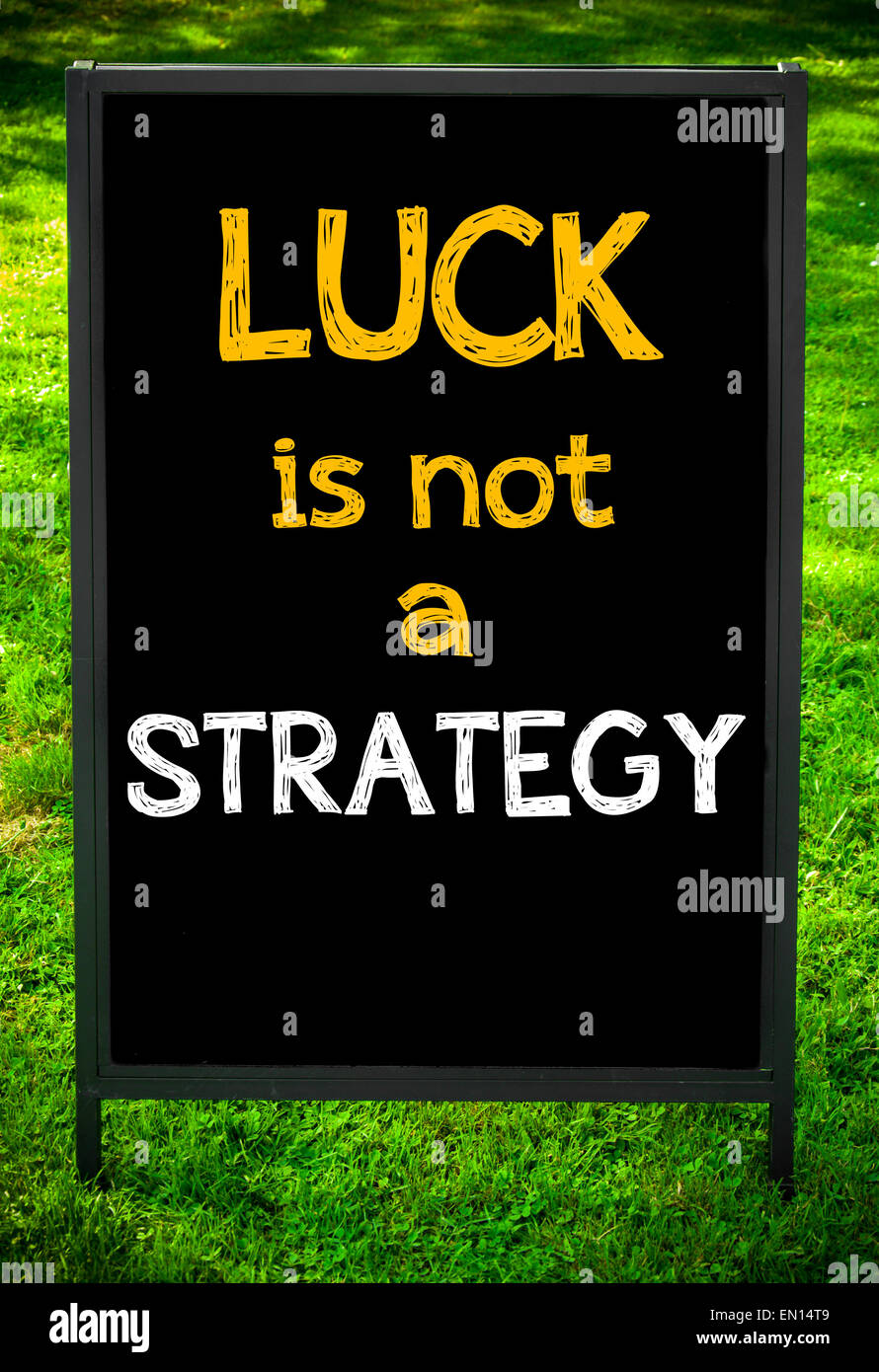 LUCK IS NOT A STRATEGY message on sidewalk blackboard sign against ...